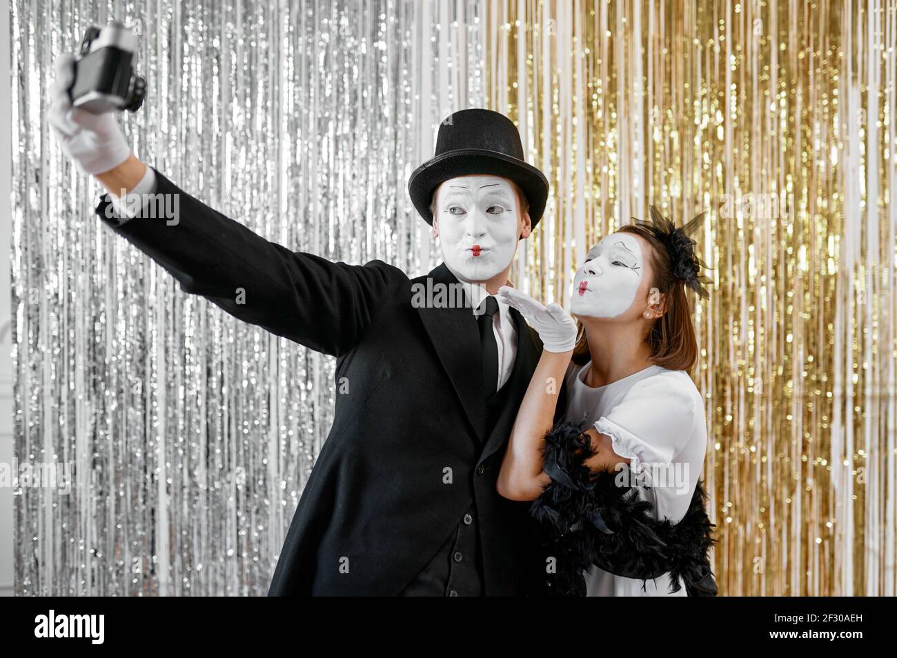 Mime artists, lady poses at gentleman with camera Stock Photo - Alamy