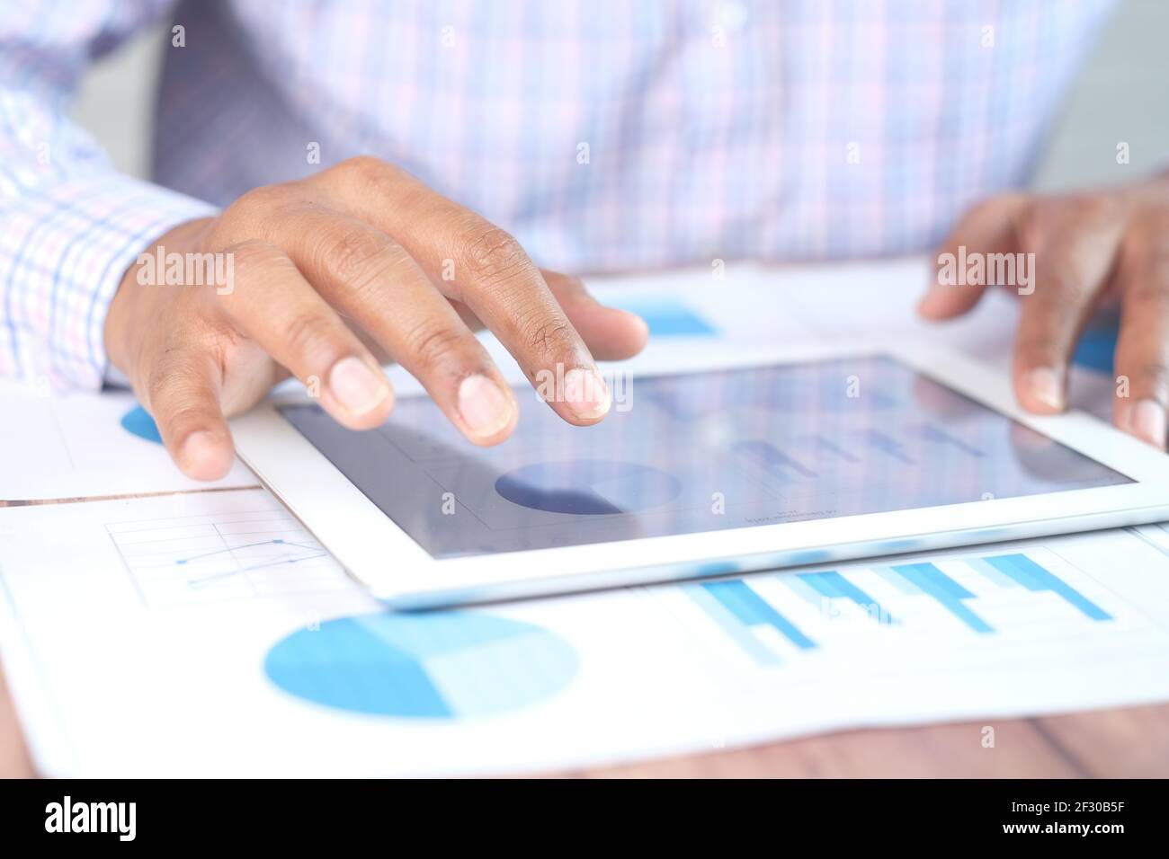 young man working on digital tablet at office desk, using self created ...