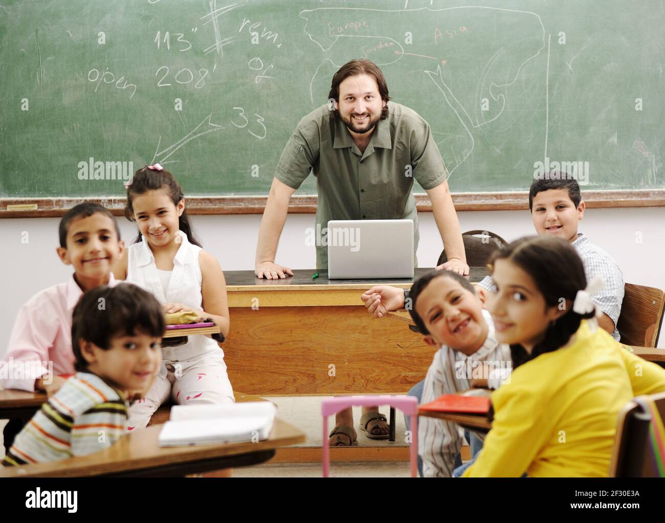 Teacher with children in classroom Stock Photo - Alamy