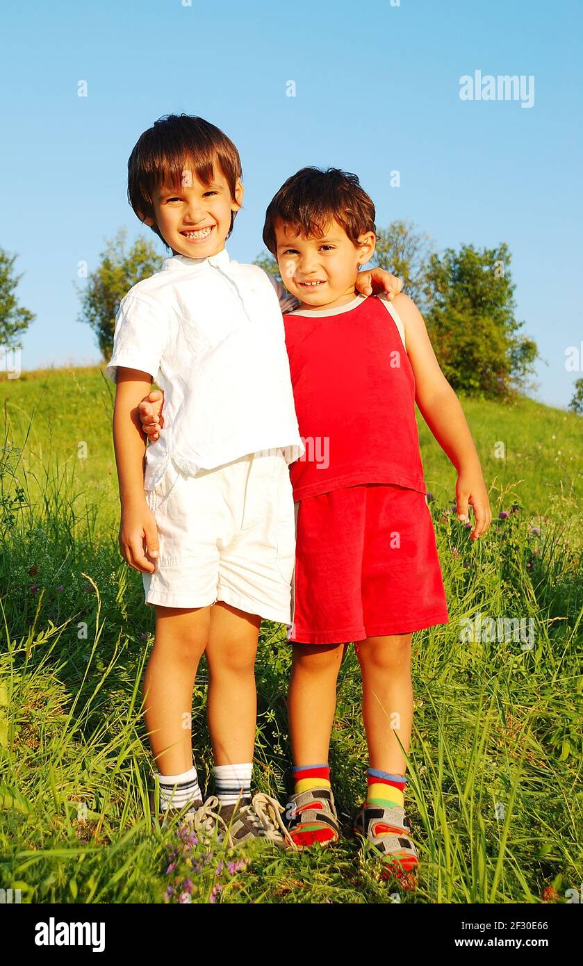 Little cute children on beautiful green field Stock Photo - Alamy