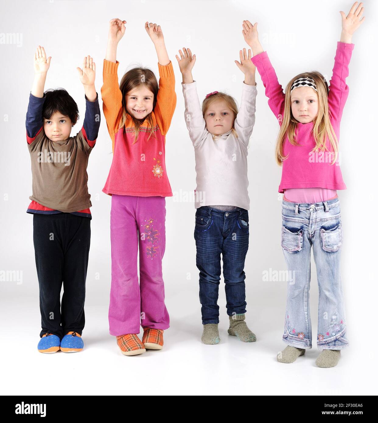 Four children group with arms up Stock Photo - Alamy