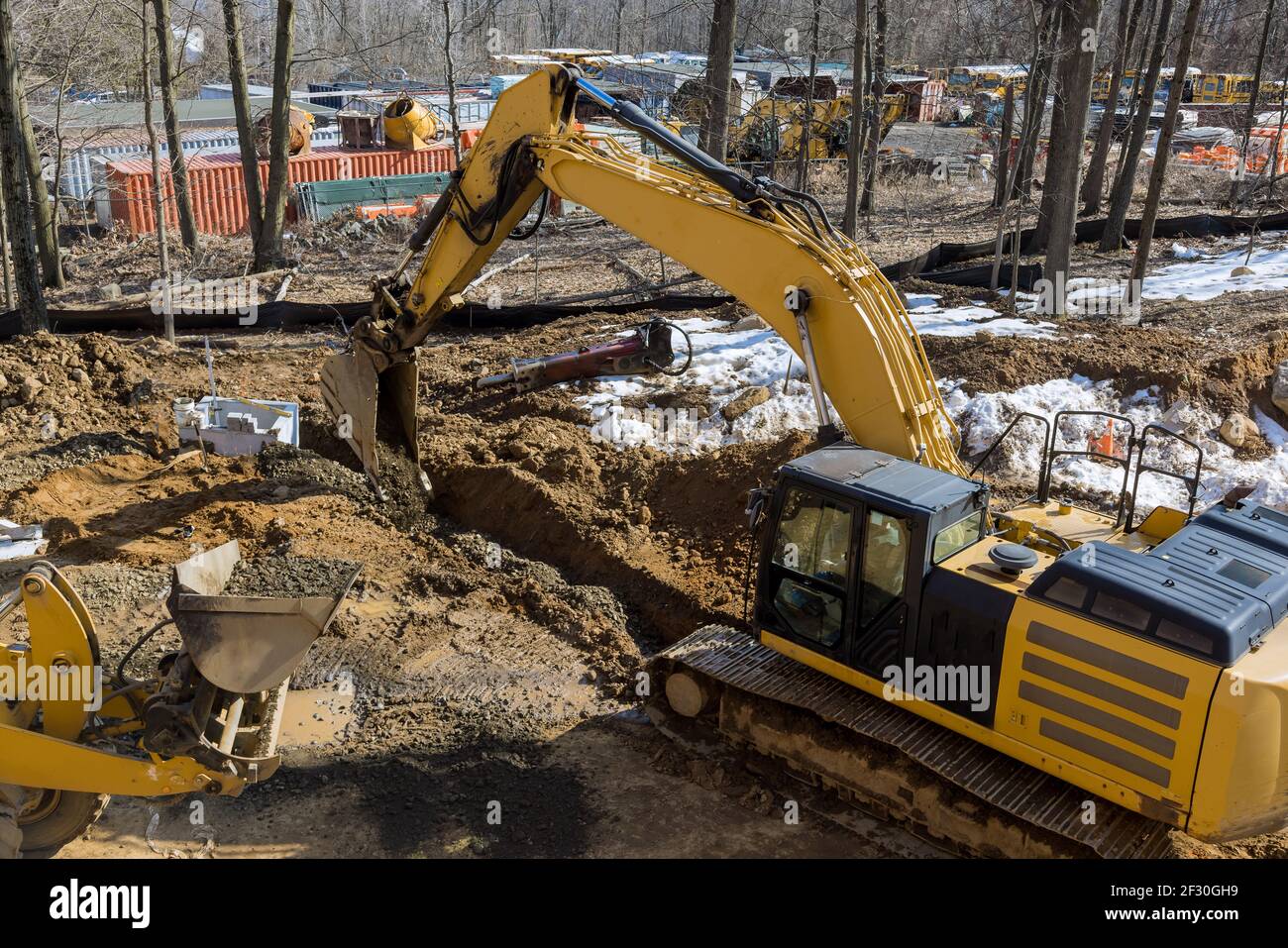Excavator is digging a huge trench, ditch for drainage canal utility ...