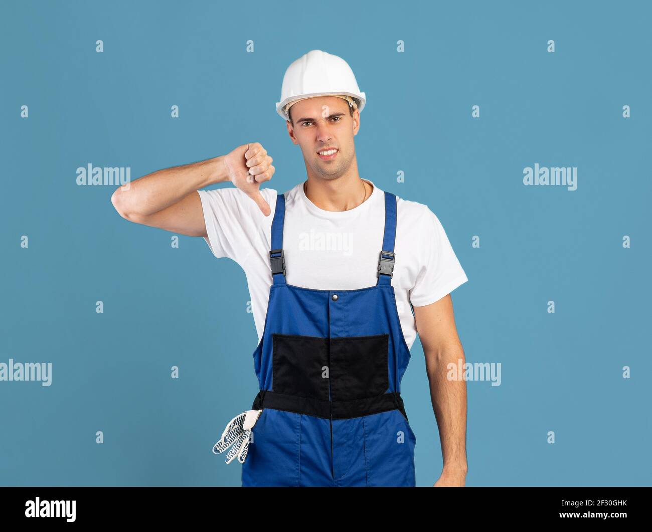 Disappointed construction worker showing thumb hi-res stock photography ...