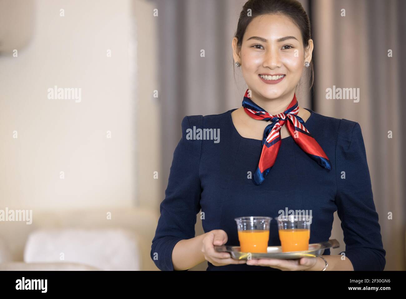 Cabin crew serve water to passenger in airplane . Airline ...