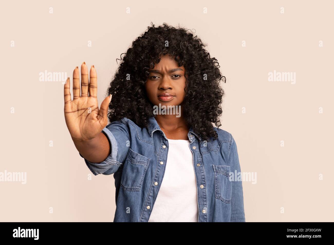 Serious black woman showing her palm, stop gesture Stock Photo - Alamy