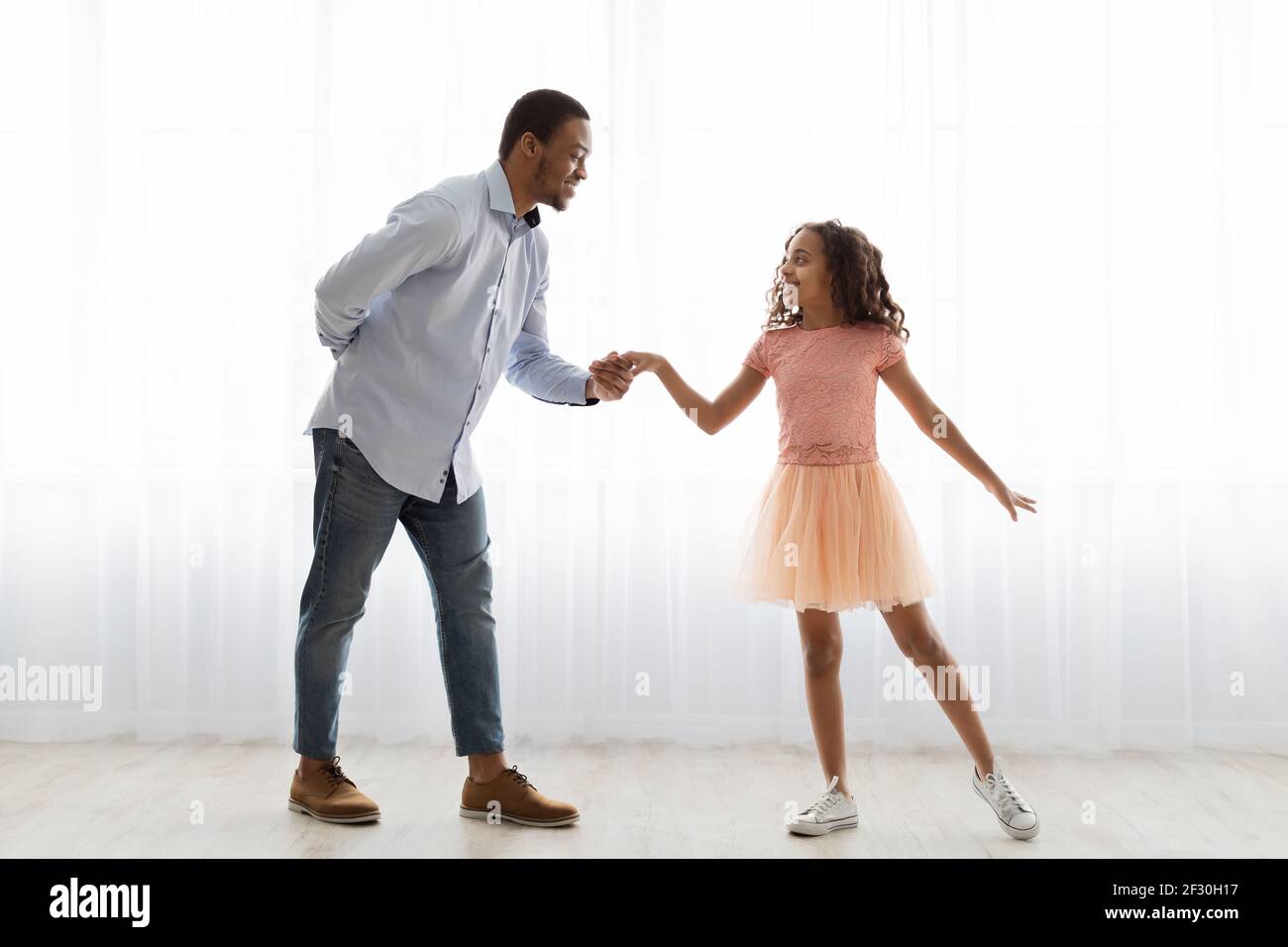 Black father and daughter dancing at home Stock Photo - Alamy