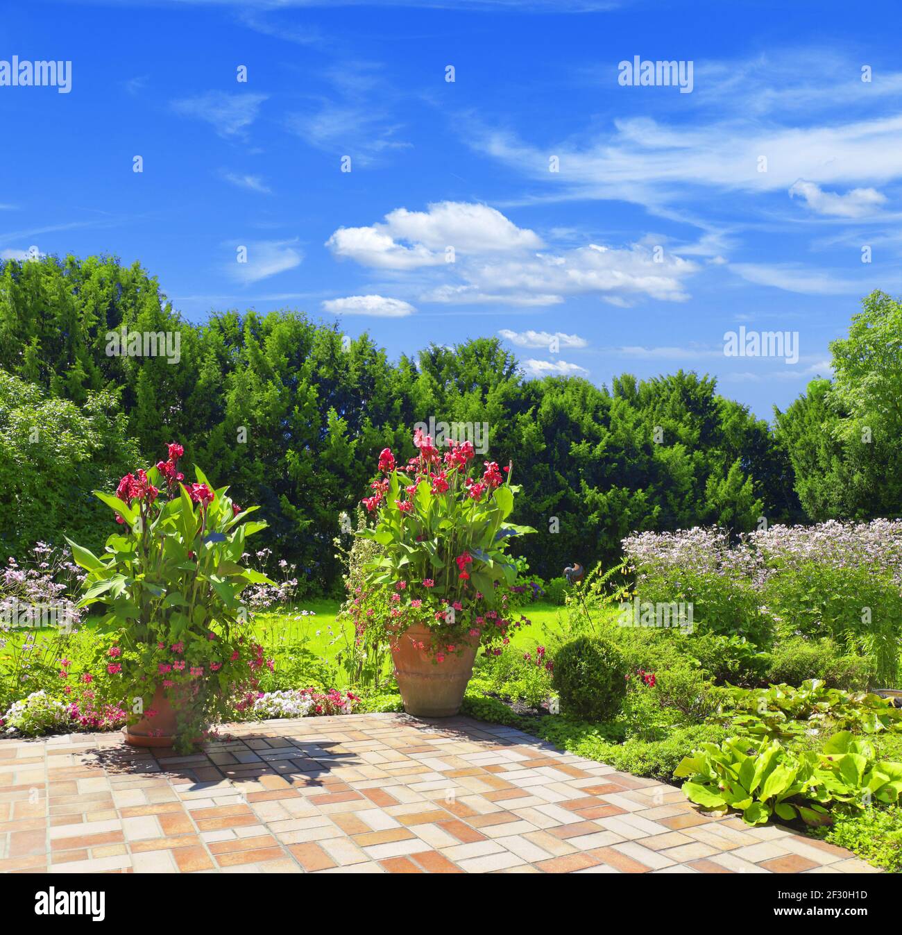 Beautiful, well-kept garden terrace with a colorful flowerbed and ...