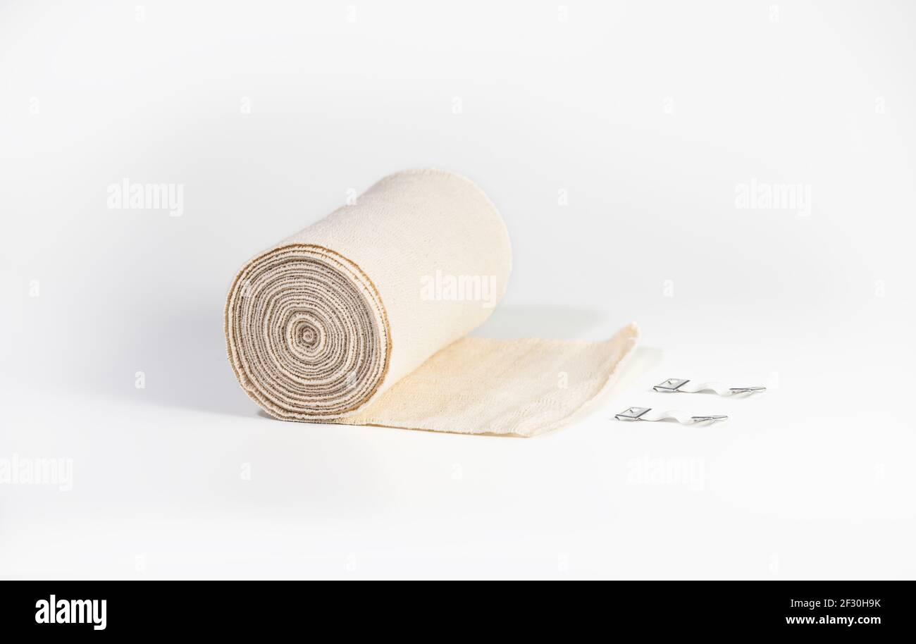 Woven elastic medical bandage rolled into roll and fixation clips ...