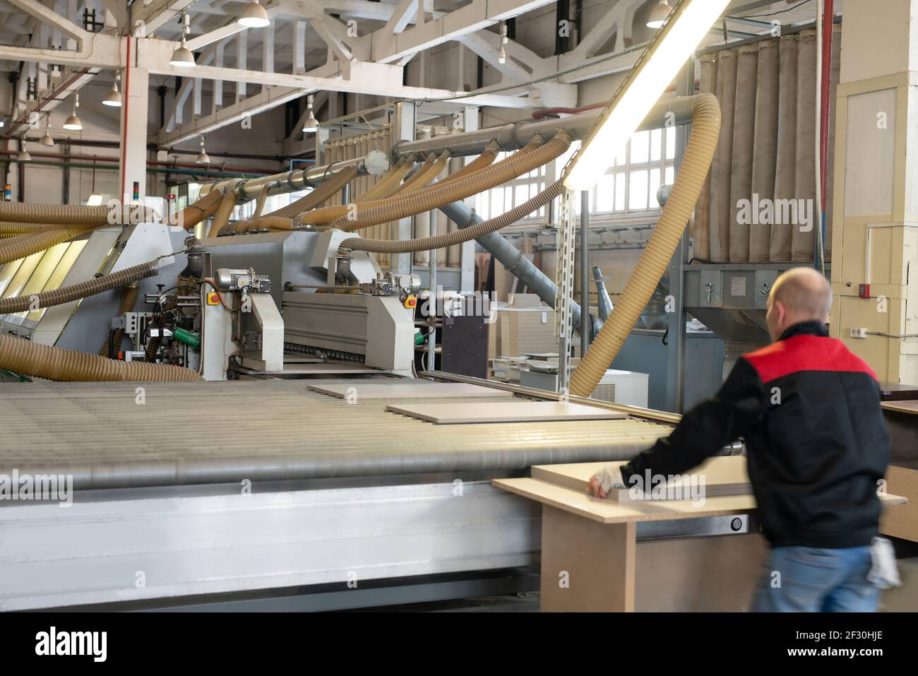 Anonymous man working with chipboard on factory Stock Photo - Alamy