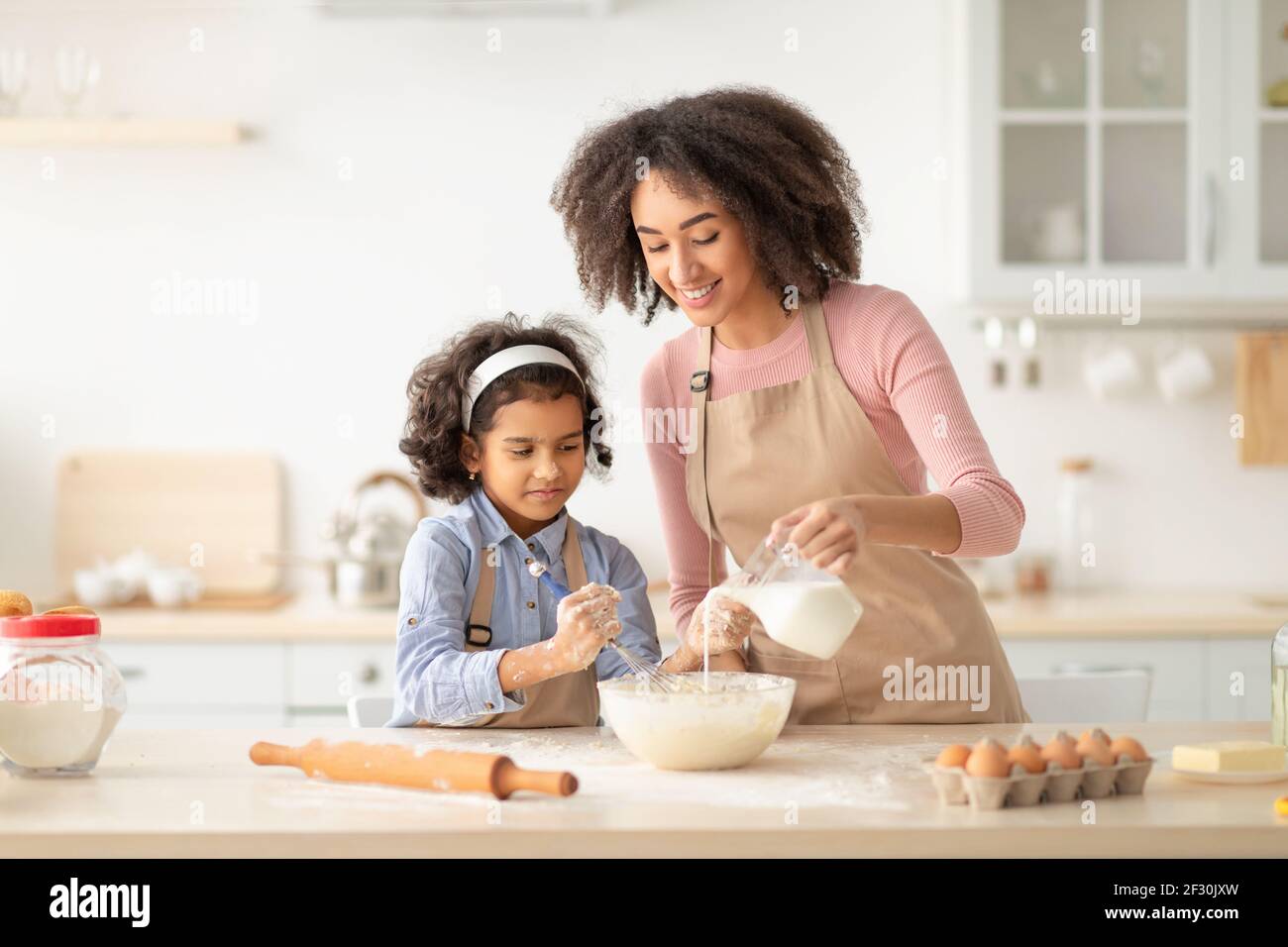 Happy black woman and daughter making pastry in kitchen Stock Photo - Alamy