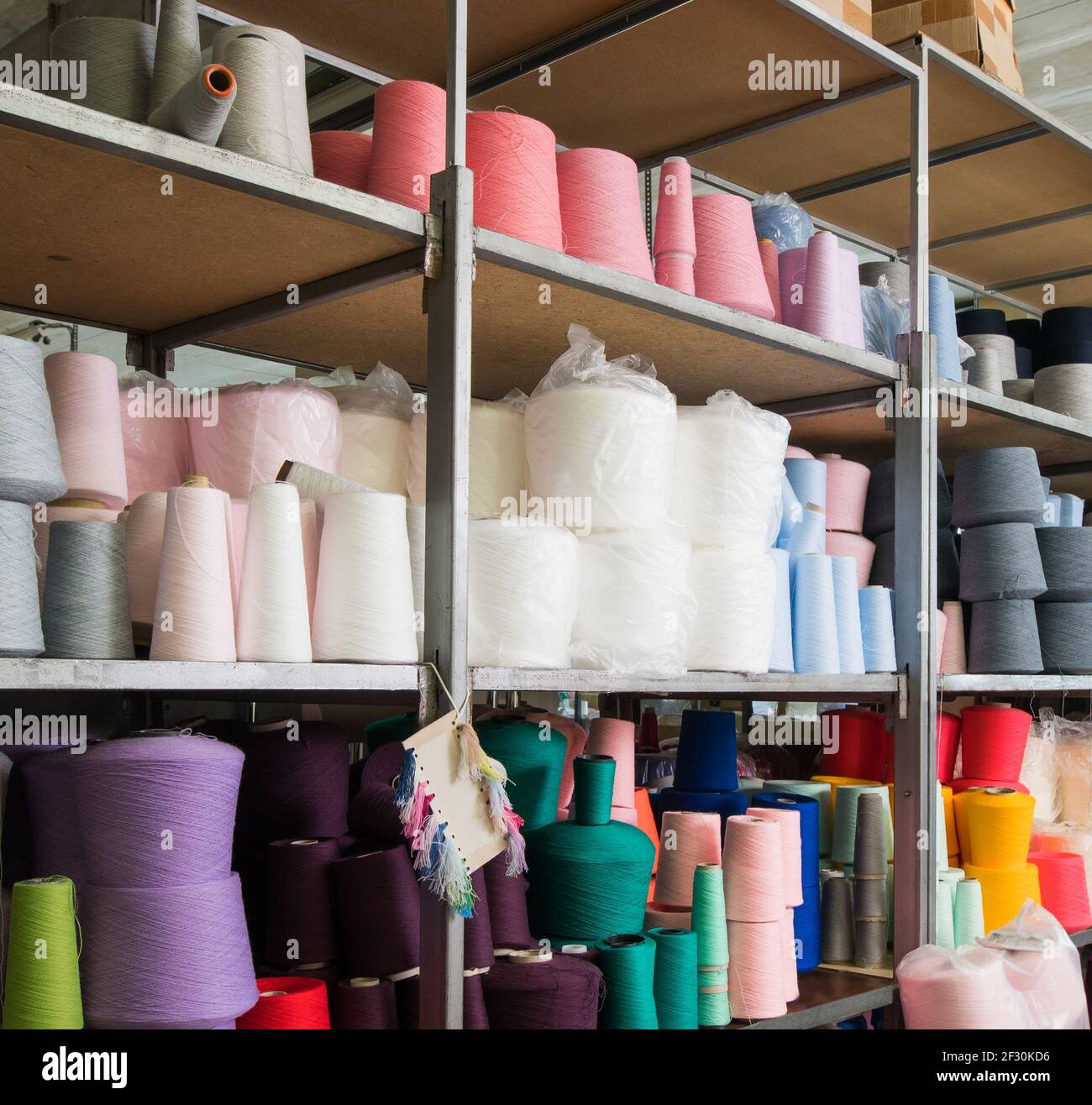Spools with different color thread at knitting factory Stock Photo - Alamy
