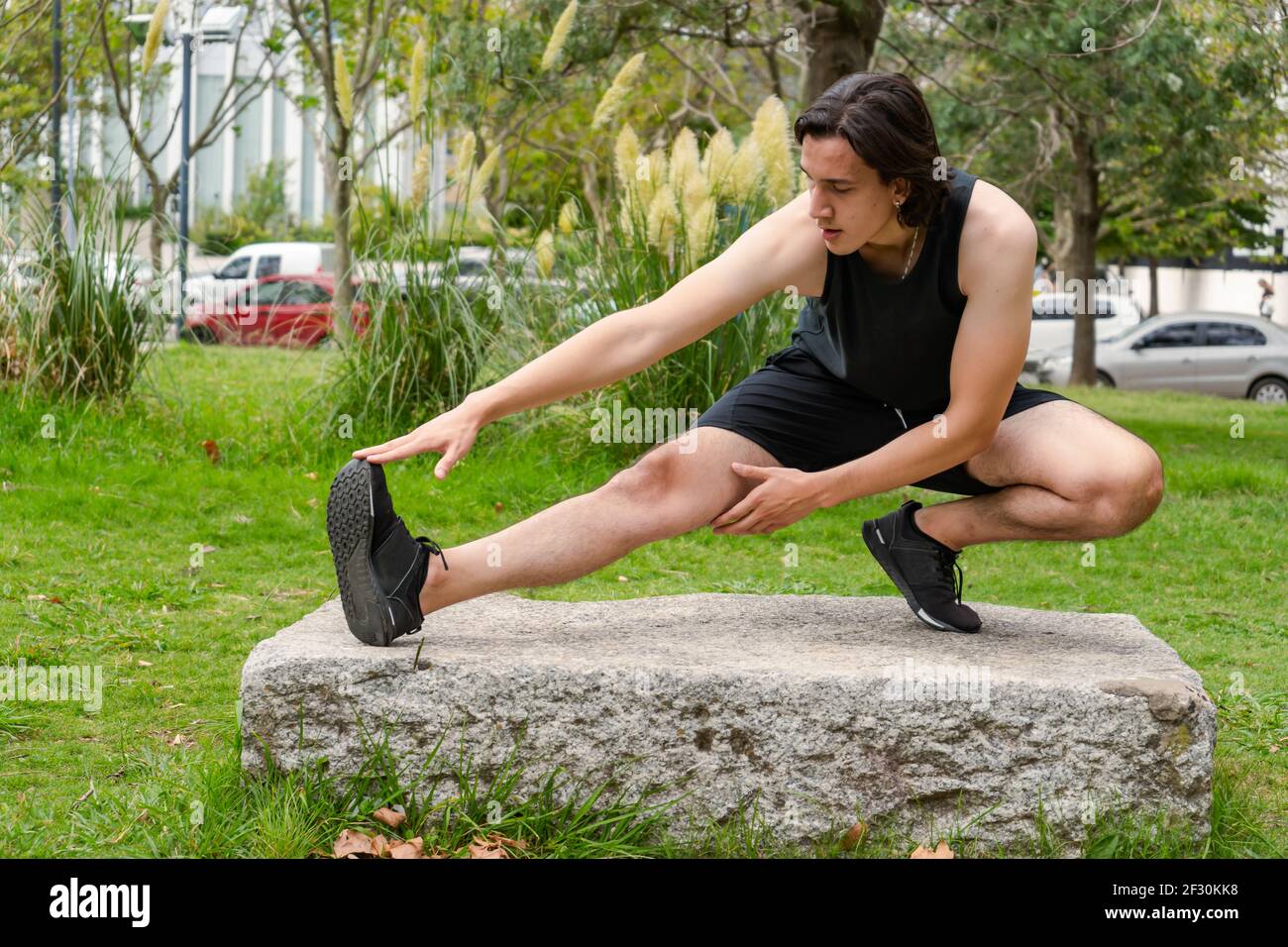 Young latino man doing muscle stretching after exercise Stock Photo - Alamy