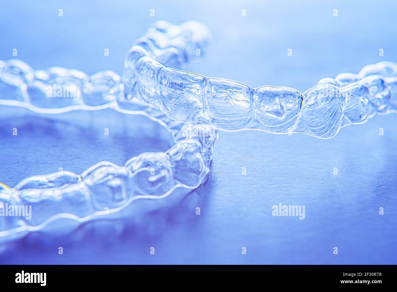 Invisible dental teeth brackets tooth aligners on blue background ...