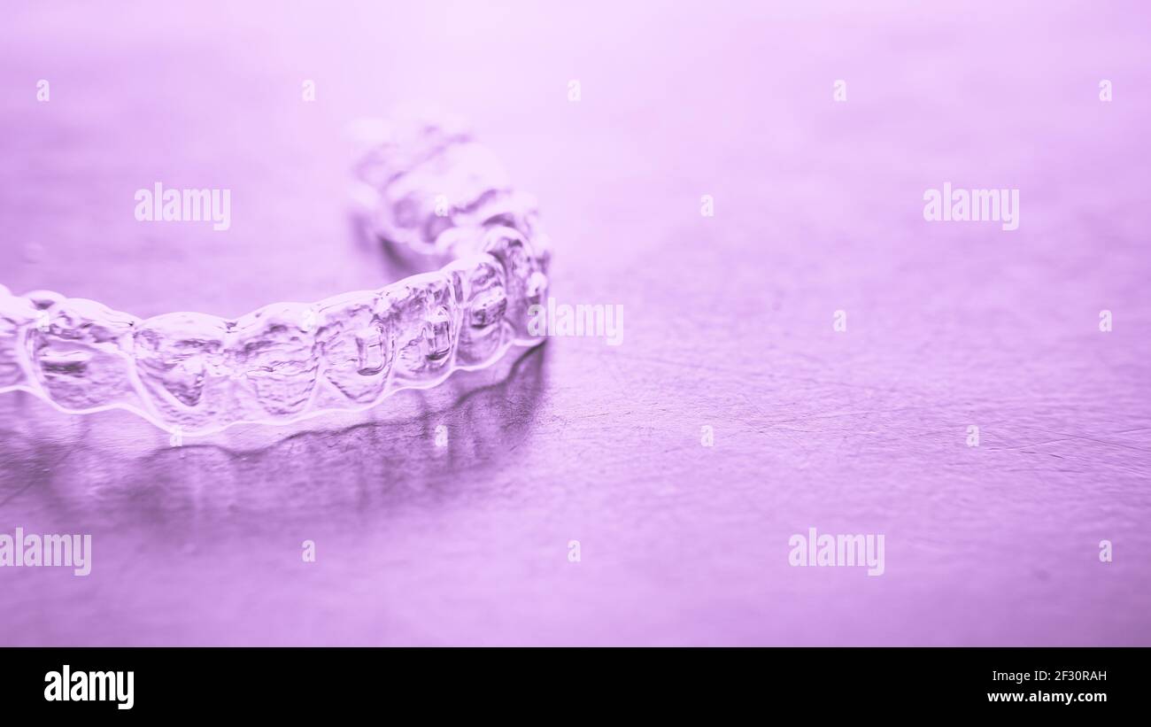 Invisible aligner teeth retainers on a pink background Stock Photo - Alamy