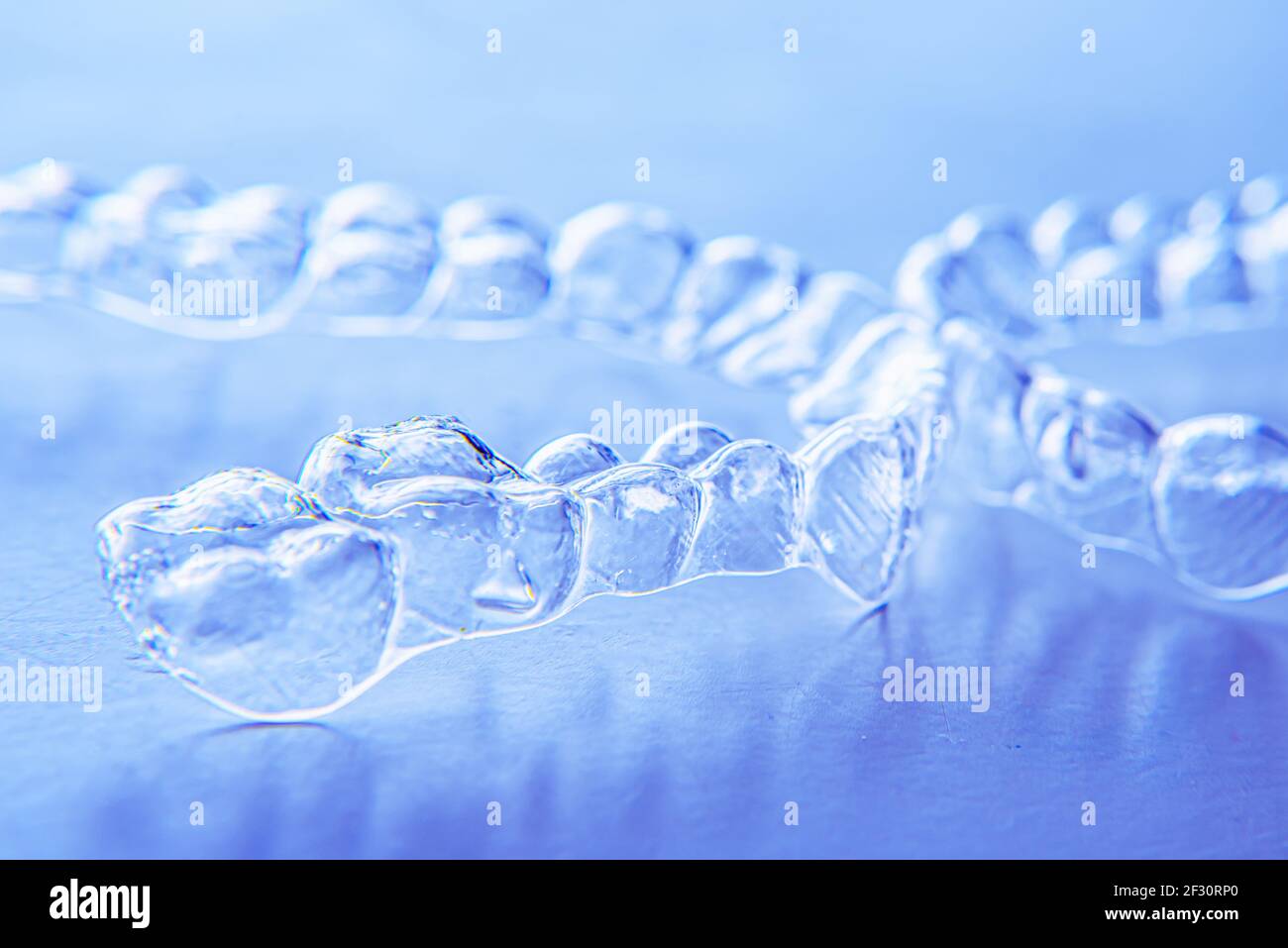 Invisible dental teeth brackets tooth aligners on blue background ...