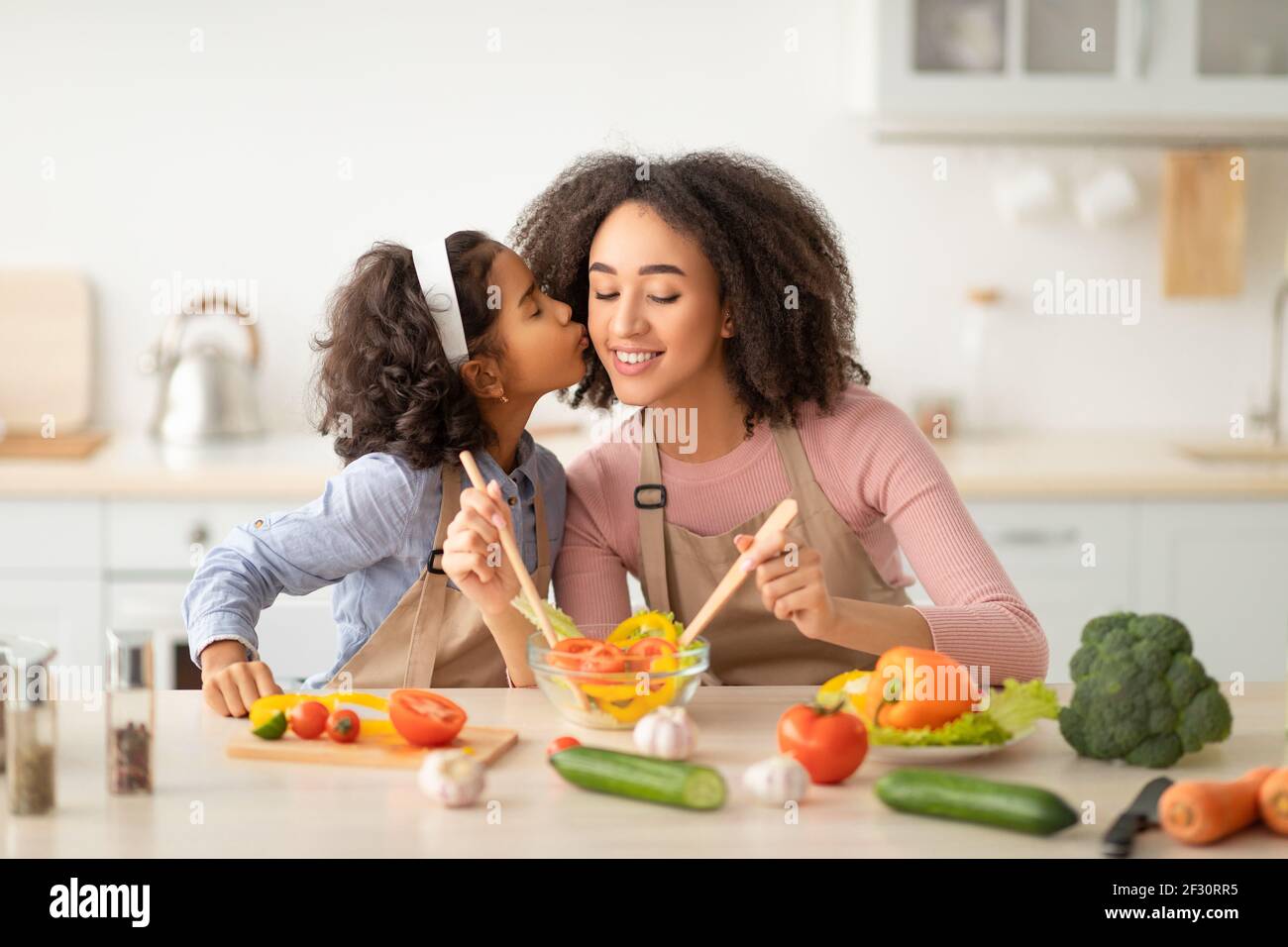 African american mother and daughter cooking vegan salad Stock Photo ...