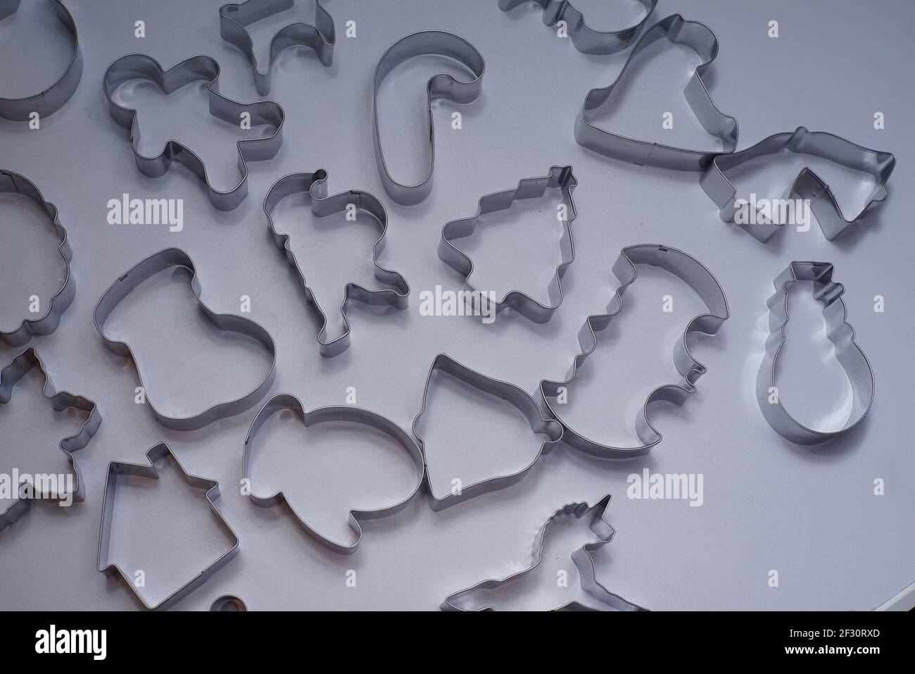 A high angle shot of different steel cookie forms on the table in the ...