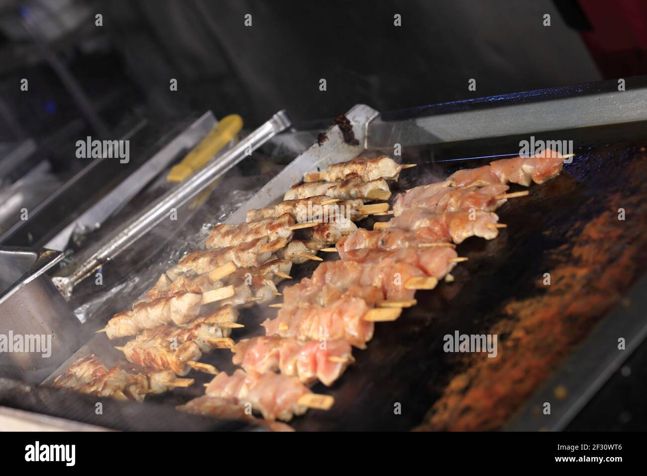 Cooking of kebab on skewers at a buffet Stock Photo - Alamy