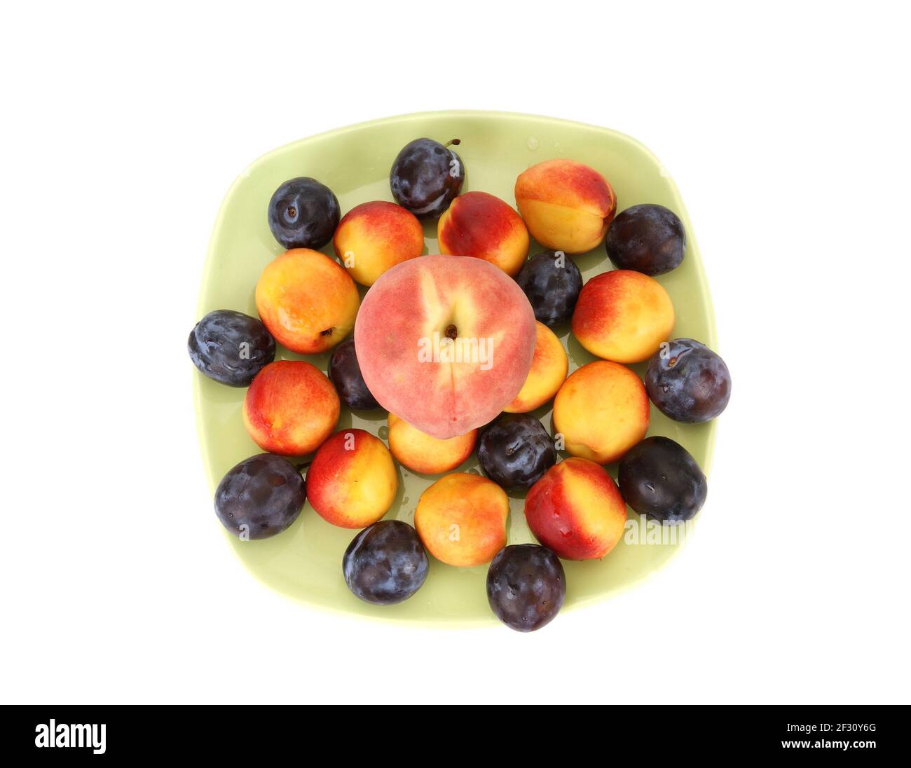 Still life with natural ripe plums and peaches on a white background ...
