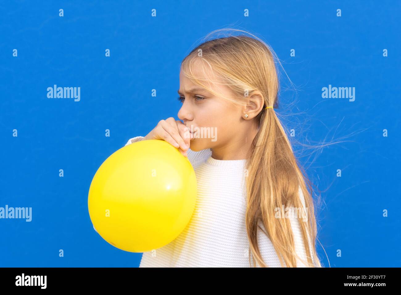 Girl blowing up balloon hi-res stock photography and images - Alamy