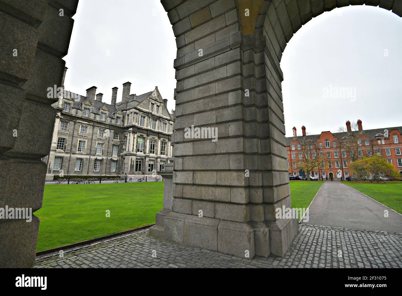 Exterior view of Trinity College through ancient stone arches in Dublin ...