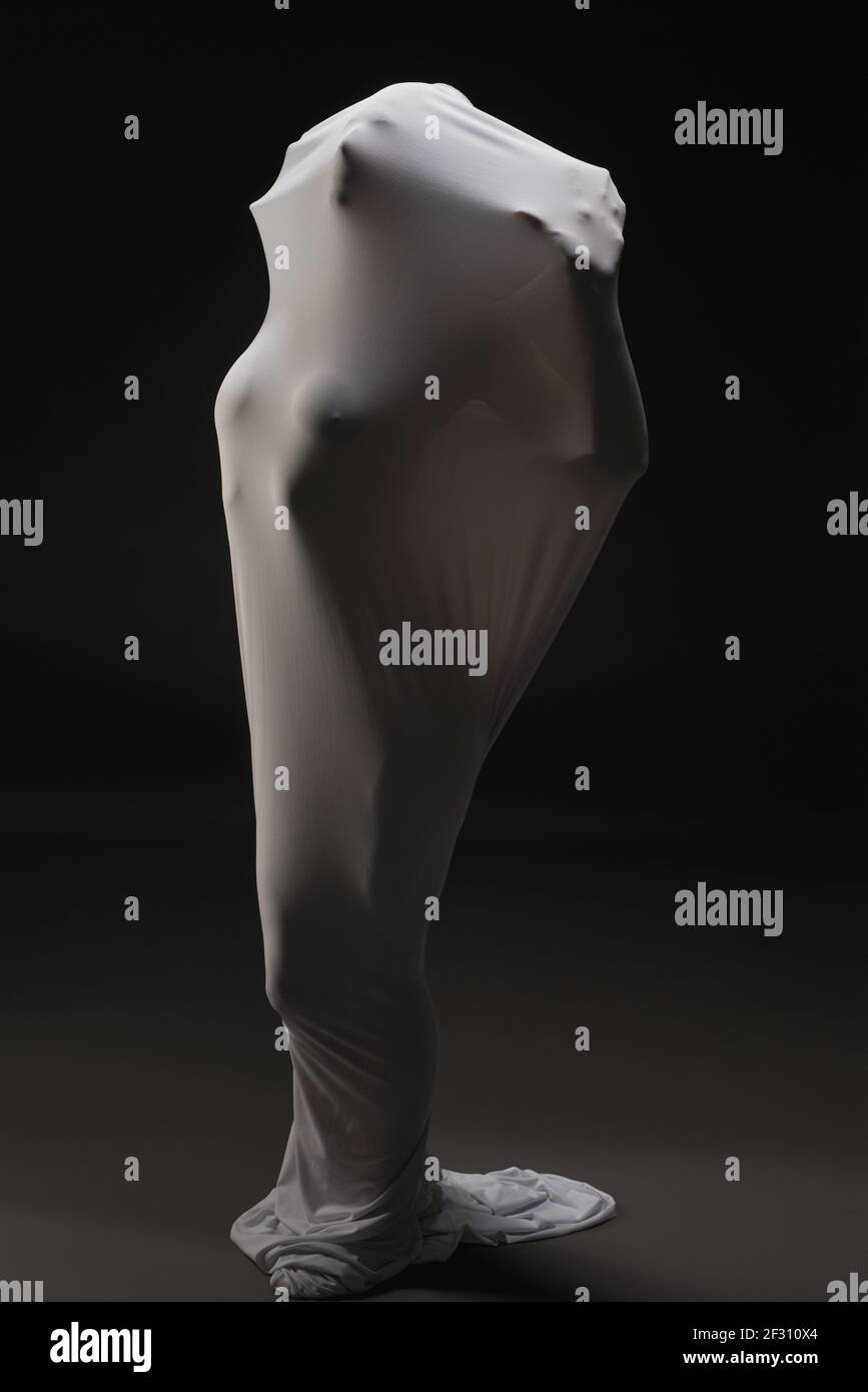 Cry woman under cloth standing in dark studio Stock Photo - Alamy