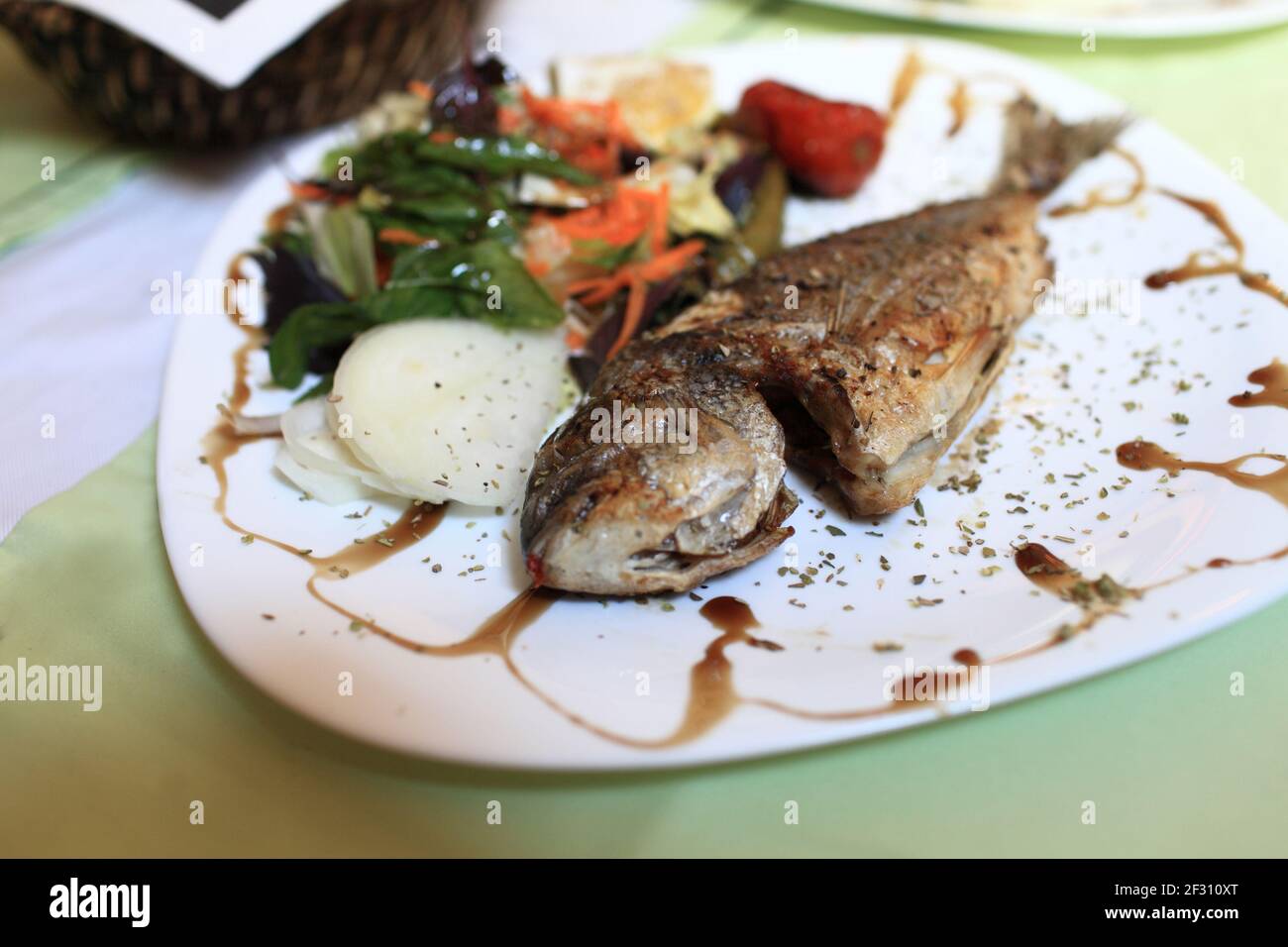 Fried dorado fish with vegetables on a white plate Stock Photo - Alamy