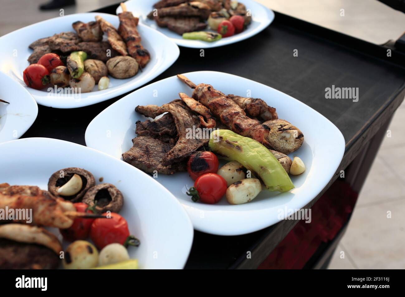 Assorted grilled meat and vegetables on the plates in a restaurant ...