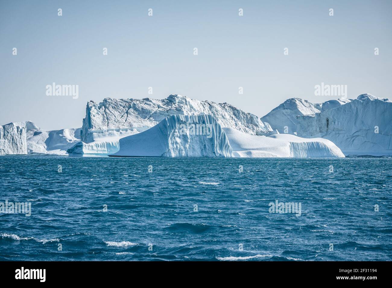 Bright sunny day in Antarctica. Full calm and reflection of icebergs in ...