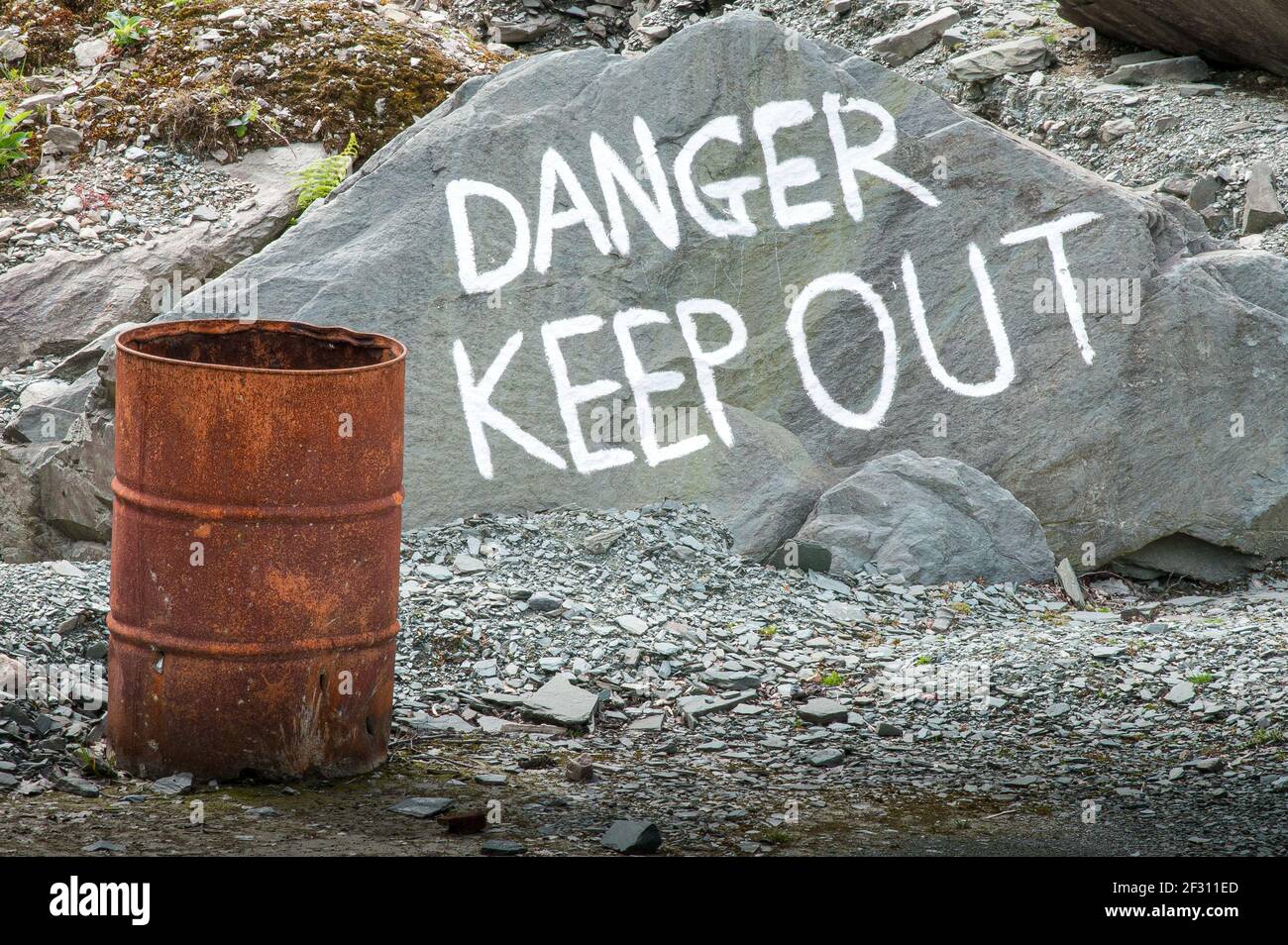 Hand painted danger sign on old slate quarry Stock Photo - Alamy