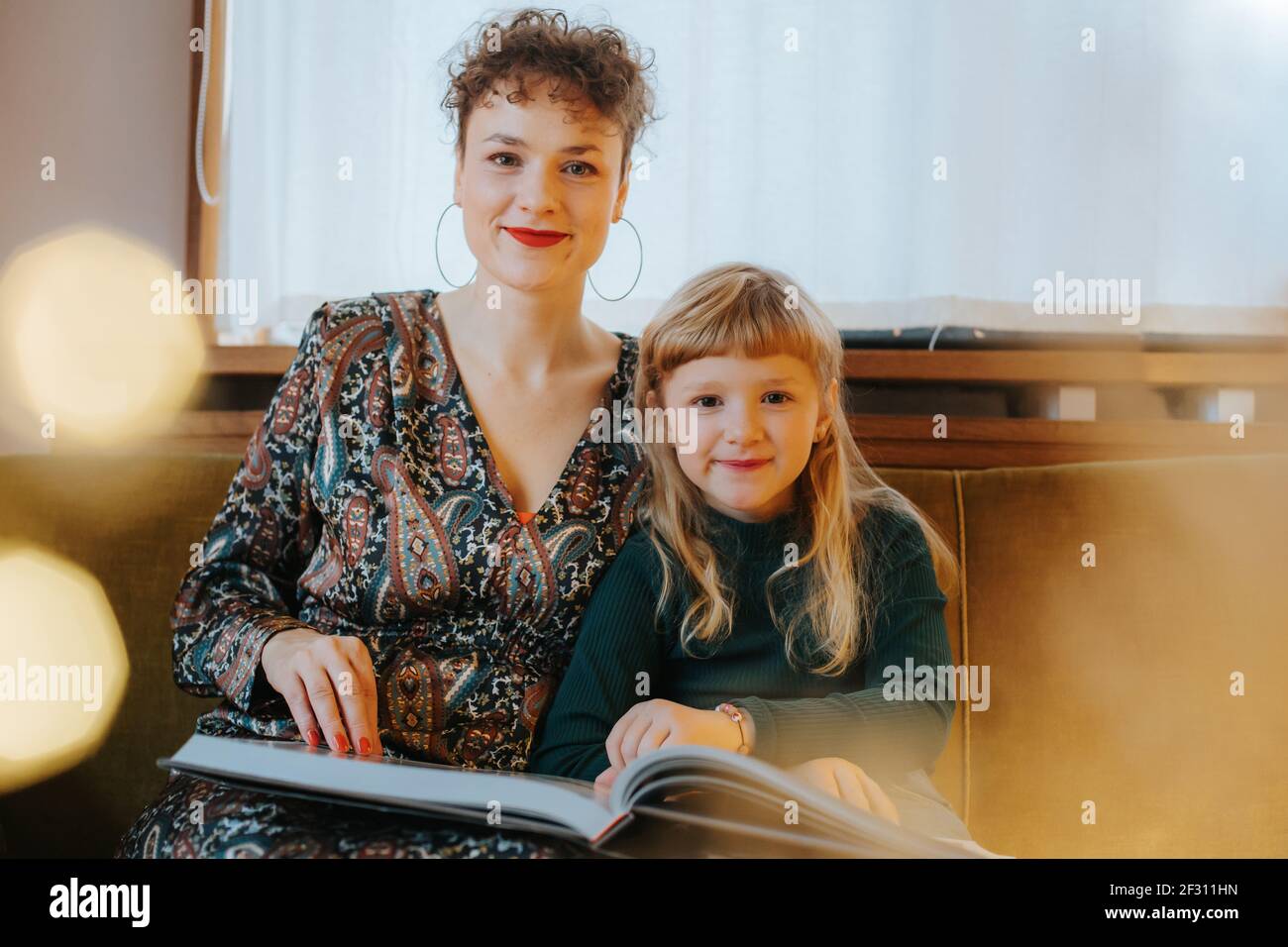 photo of mother and daughter reading a book Stock Photo - Alamy