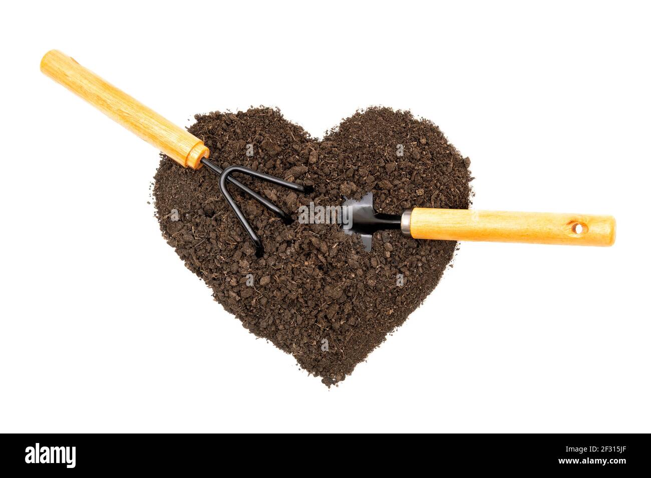 Garden hand transplanter and cultivator in a heart shaped pile of soil ...