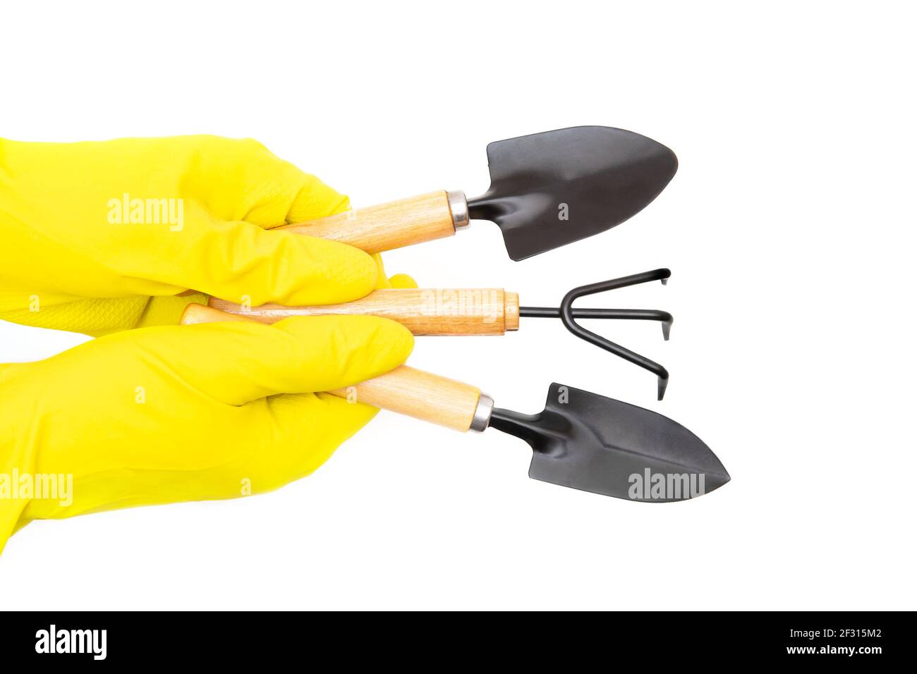 Crop view of human hands in yellow gloves holding a kit of garden hand ...