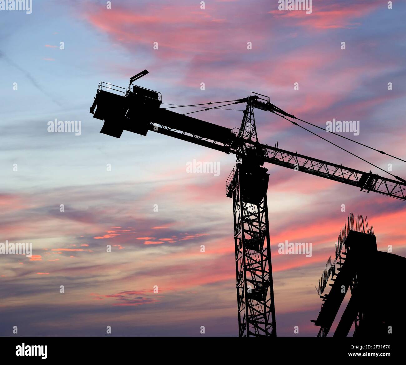 Building crane at the background of a multi-storey building under ...