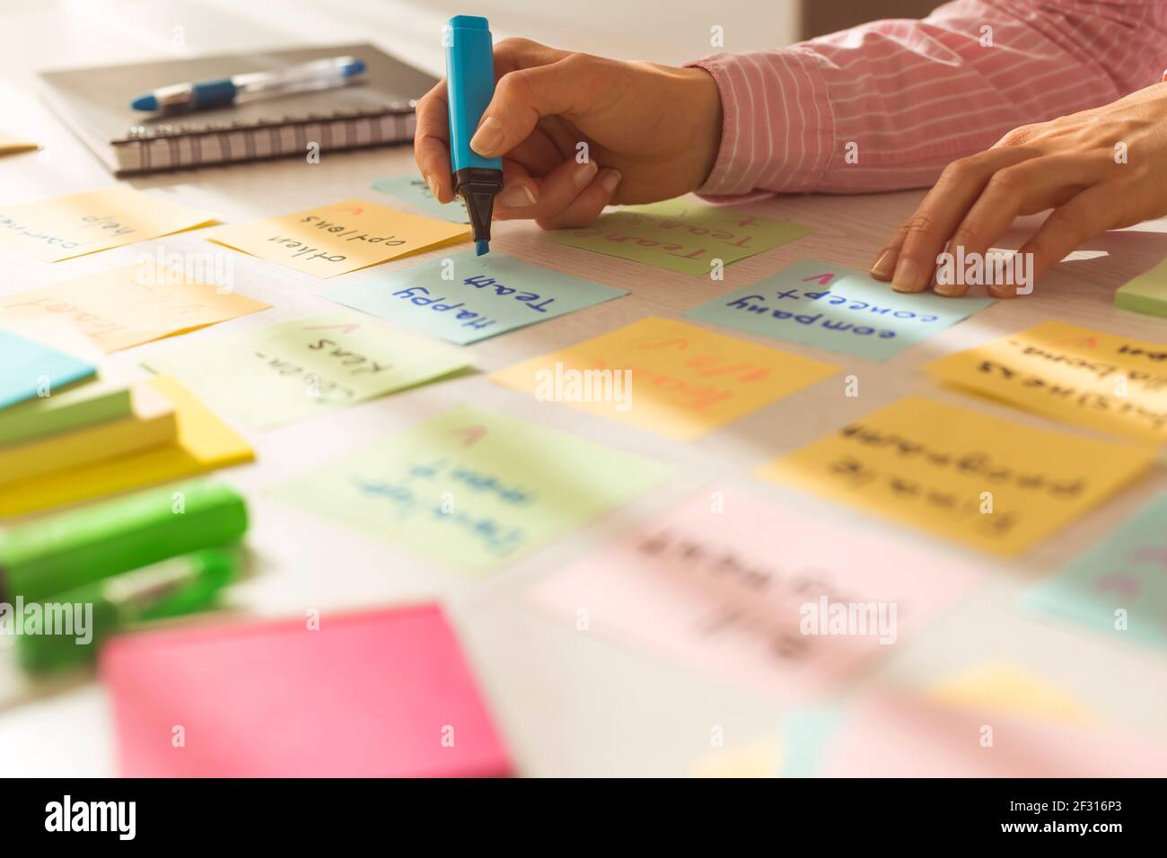 Business woman working on a project using sticky notes on her desktop ...