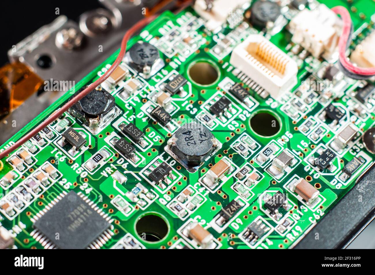 Green electronic board with many capacitors and resistors close-up ...