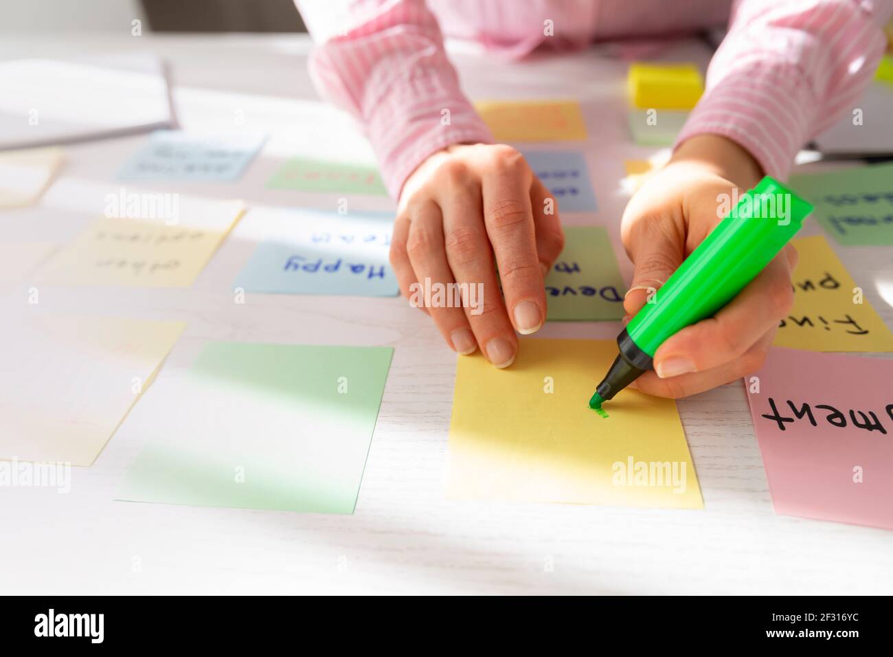 Business woman working on a project using sticky notes on her desktop ...
