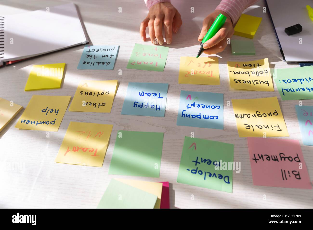Business woman working on a project using sticky notes on her desktop ...