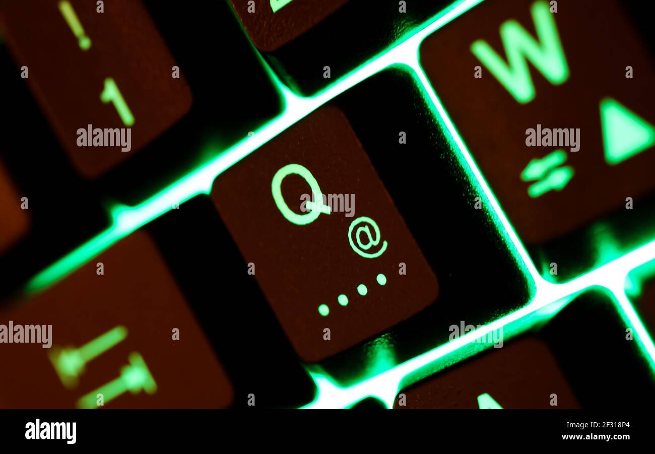 Macro closeup of isolated green illuminated key with letter Q and at ...