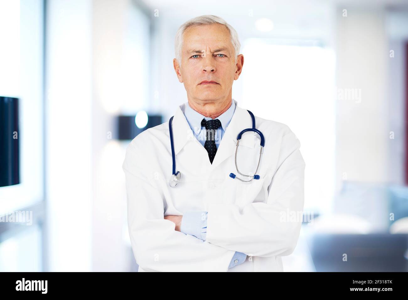 Shot of serious face male doctor standing with arms crossed in the ...