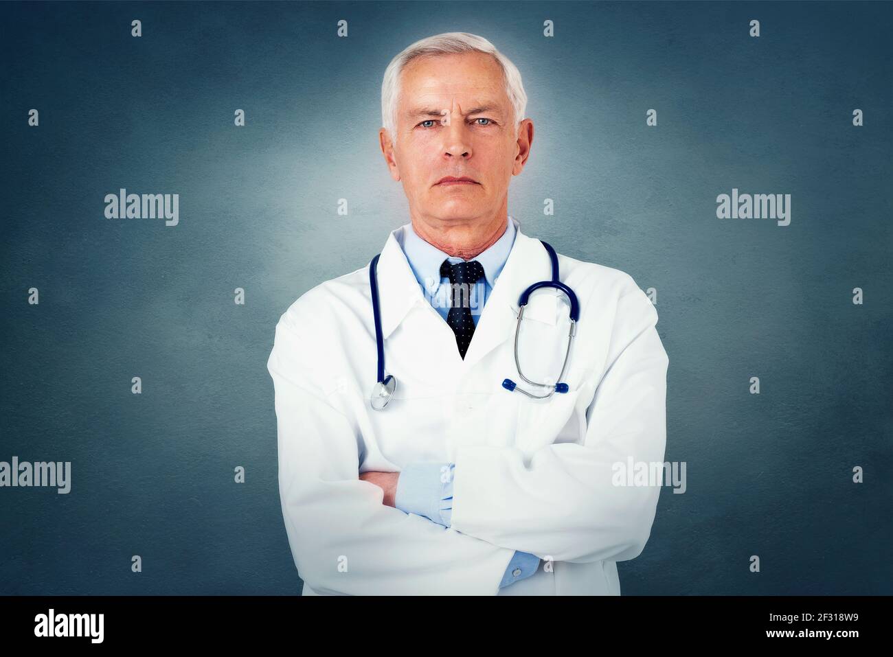 Portrait shot of senior face doctor stanading with arms crossed at ...