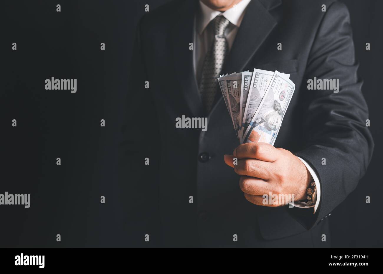 Businessman hand grabbing money, US dollar (USD) bills on black ...