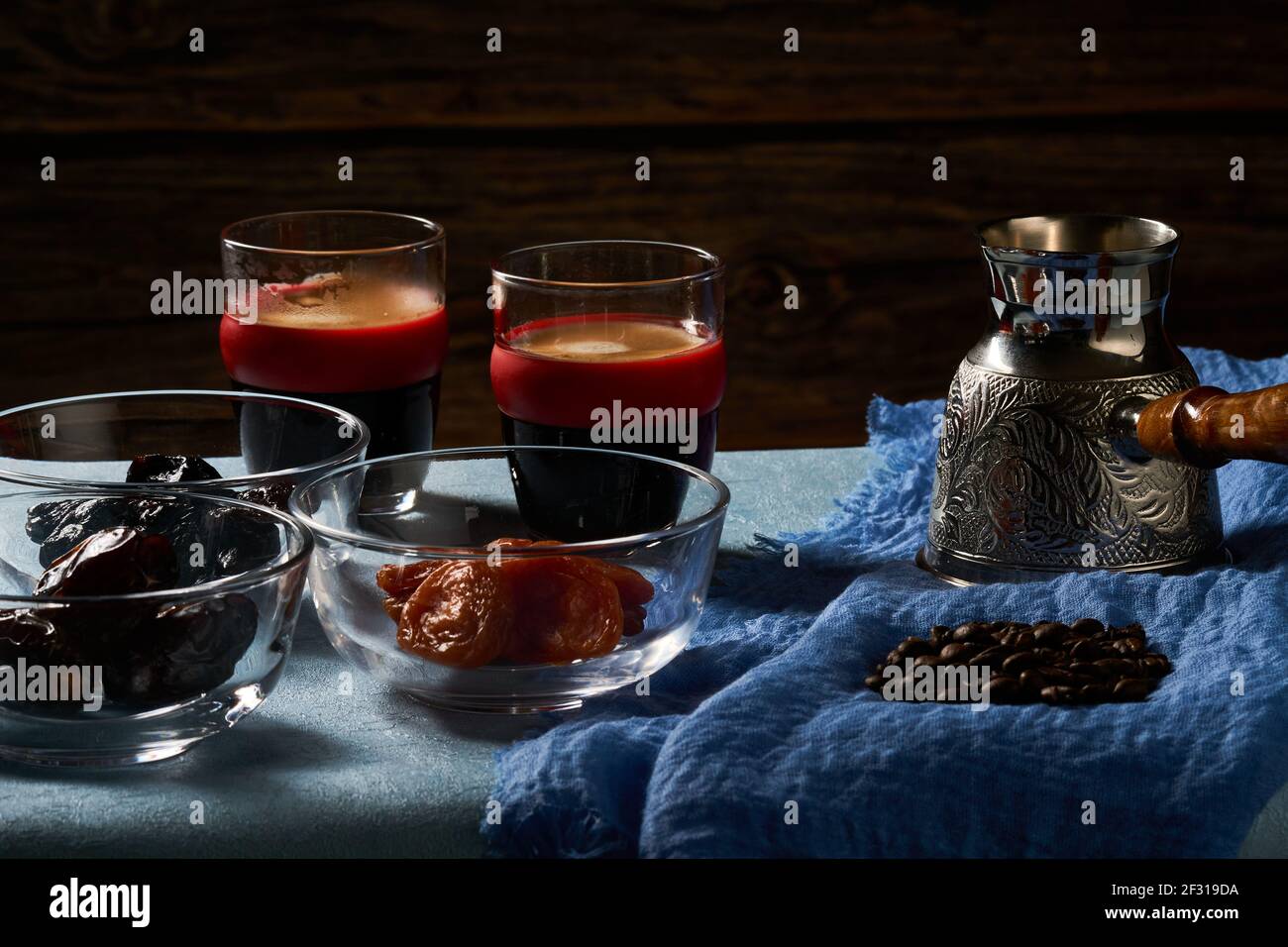 Coffee pot (Cezve), coffee beans, two glasses of coffee, dry apricot ...