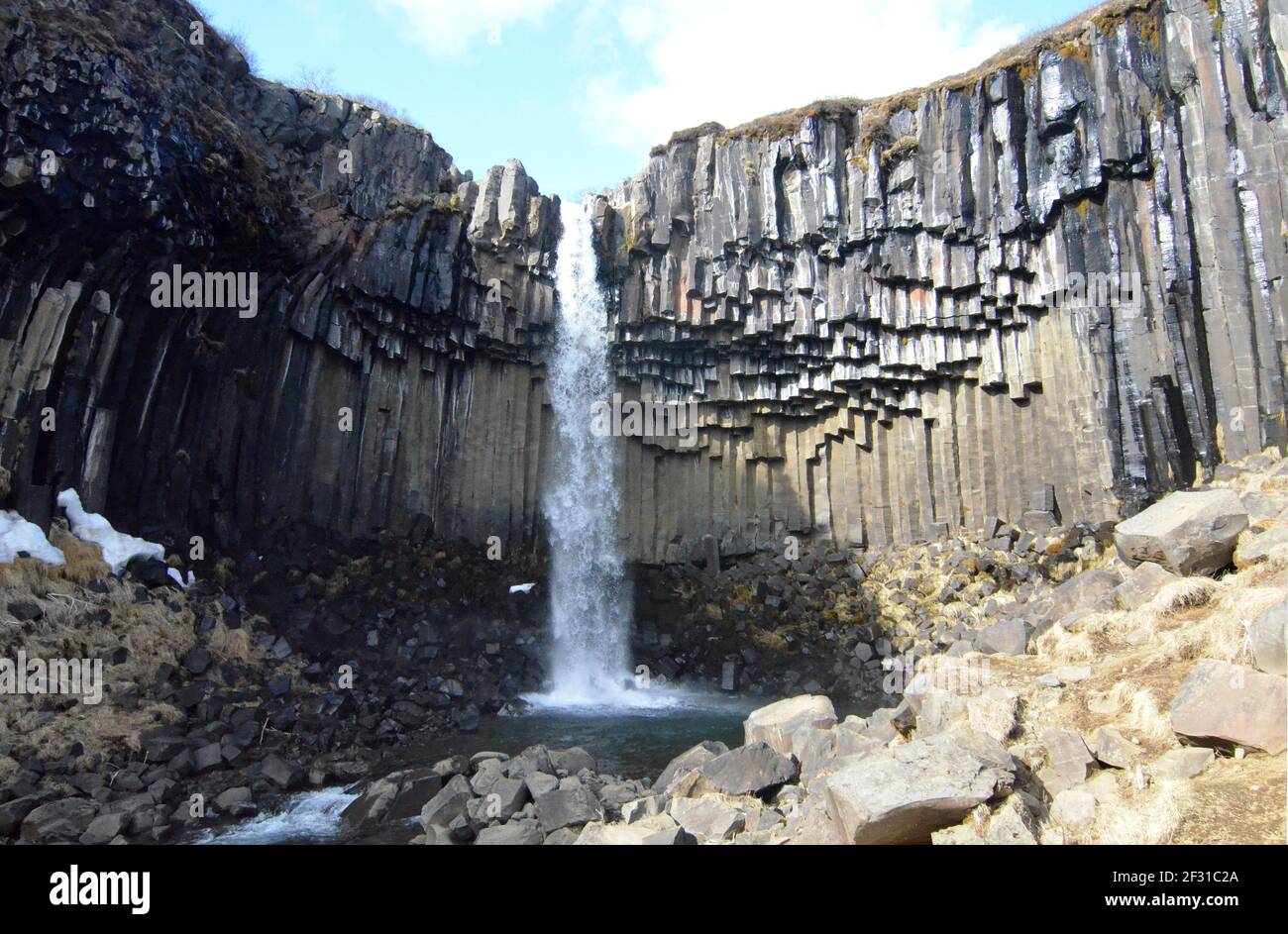Large basalt column waterfall pouring over the cliff in Iceland Stock ...