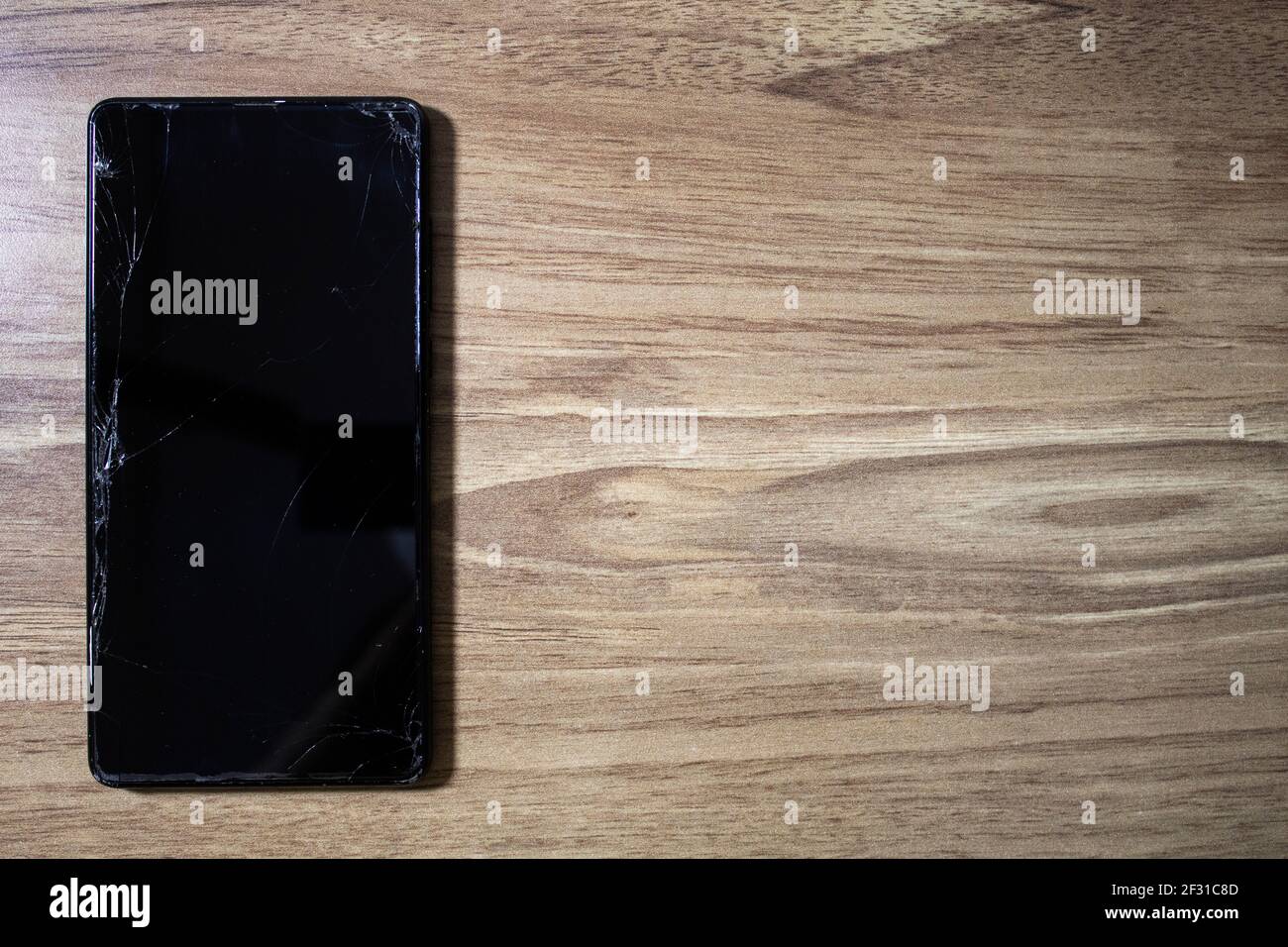 Broken phone on stall screen on wooden table. Smartphone with cracks on ...