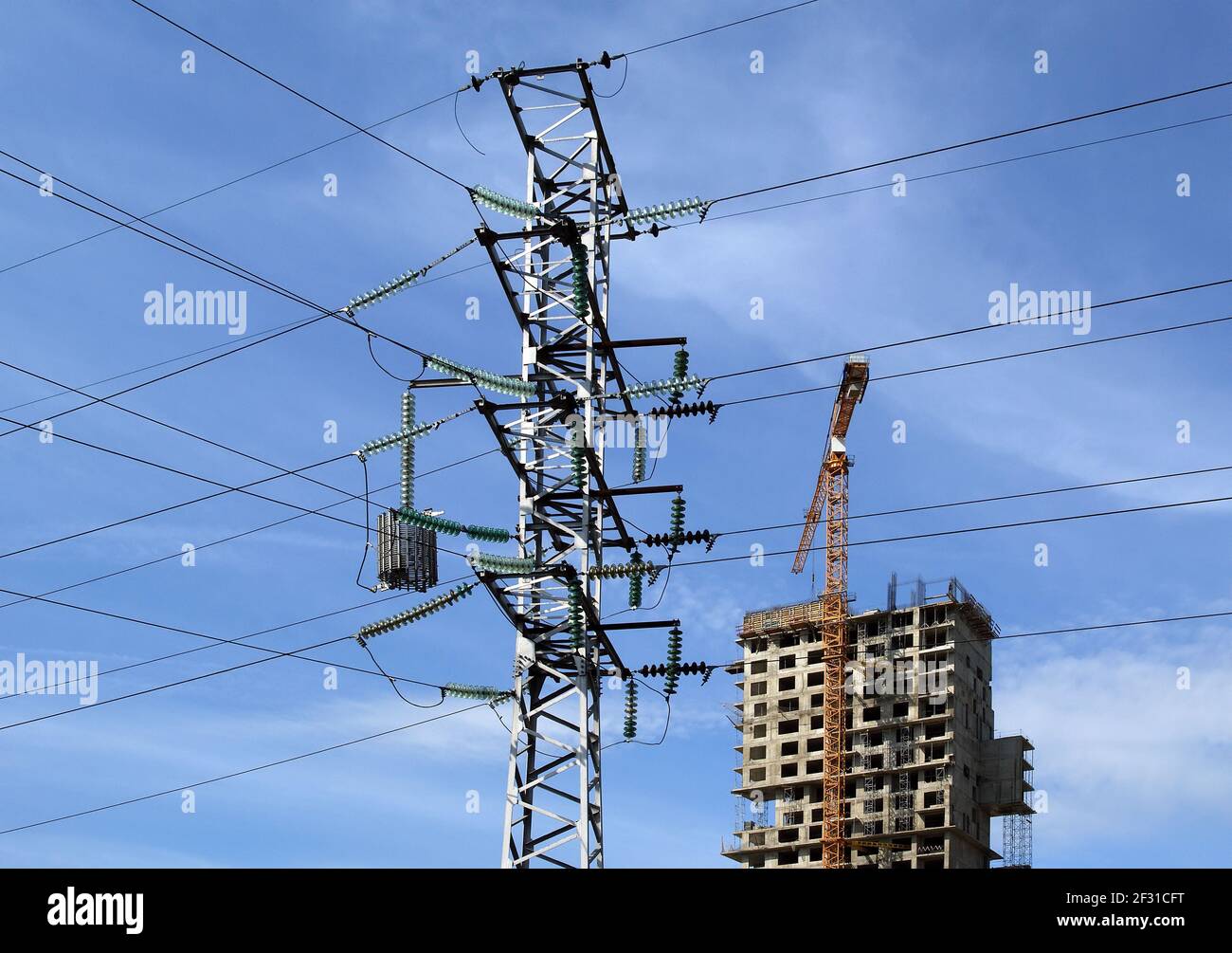 electric pylon and building crane at the background of building under ...