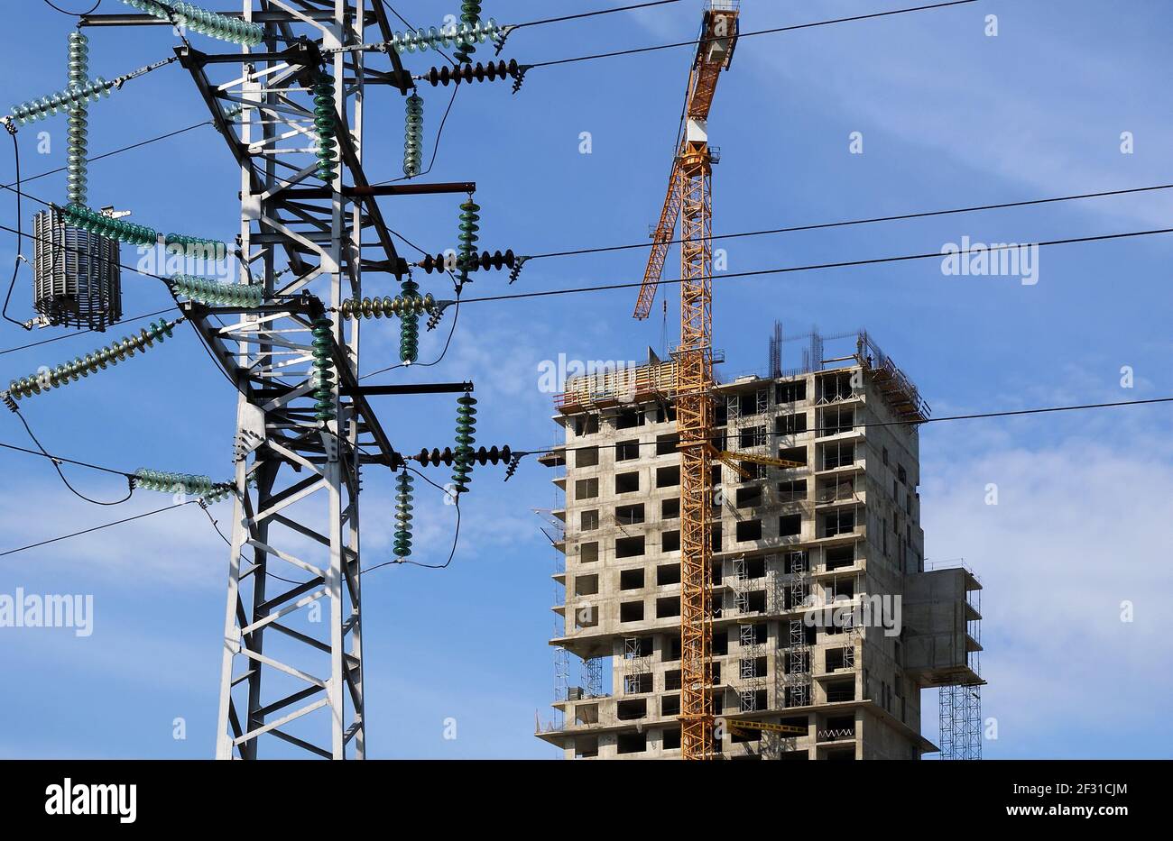 electric pylon and building crane at the background of building under ...