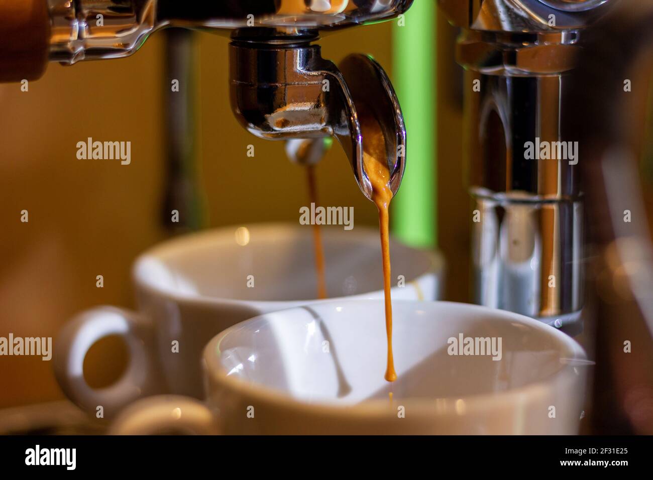 A portrait of the nozzle of a coffee machine. There is freshly grounded ...