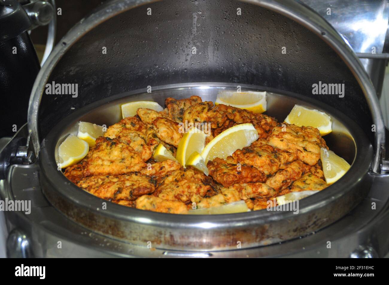 Buffet chicken chicken pieces with lemon Stock Photo - Alamy