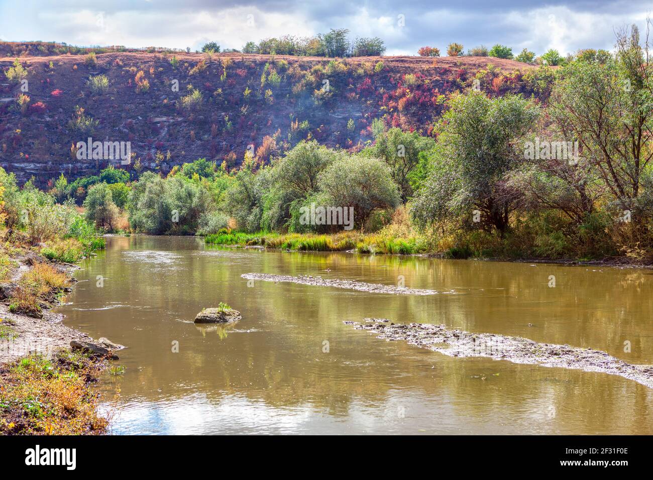Shallow river water surrounded by hills Stock Photo - Alamy